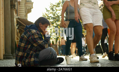 Homeless begging tourists throw coin money into cup and recalculates ...