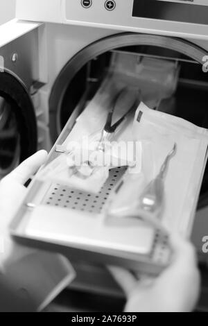 The dentist's assistant adds the packaged dental instrument to the ...