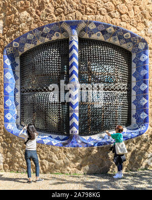 Tourists photograph mosaic tiling on a building by Antoni Gaudi at the ...