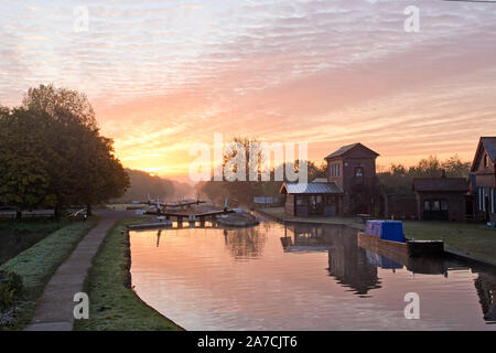 The sun breaks through the fog as it rises on a frosty and cold ...