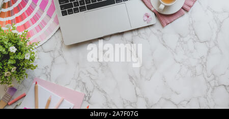 Overhead shot of pink feminine designer workspace with laptop computer ...
