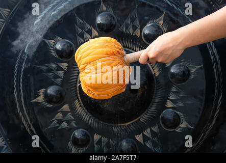 Zen monk sounding a hand-bell called inkin during a buddhist ceremony ...
