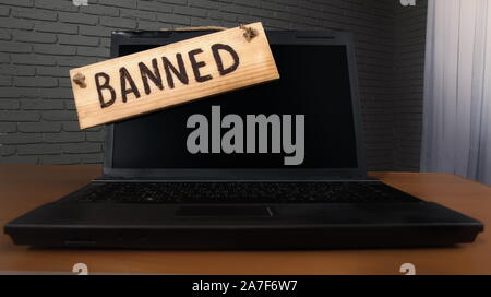 turned off laptop with a wooden sign that says banned Stock Photo - Alamy