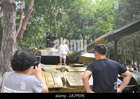 Citizens pose to photo with warcraft, tank, machine gun and other army ...