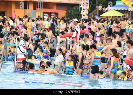 Tourists crowd a swimming pool at the Chimelong Water Park to cool off ...