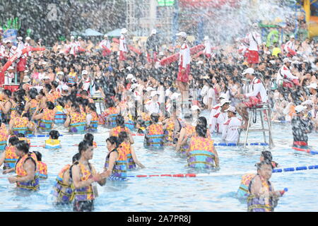 Tourists crowd a swimming pool at the Chimelong Water Park to cool off ...