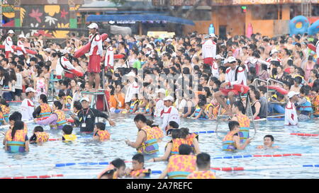 Tourists crowd a swimming pool at the Chimelong Water Park to cool off ...