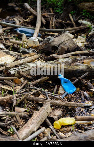 Plastic pollution muddy puddle with bottles waste and styrofoam on ...