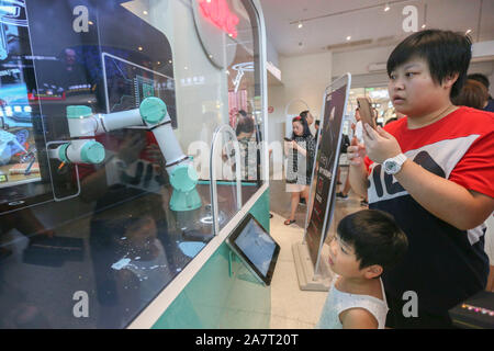 A robot arm makes an ice cream for customers at a fastfood restaurant ...