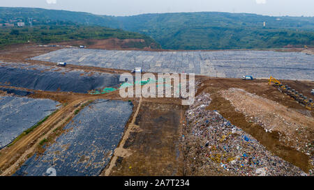 Chinese workers sort out and bury kitchen waste at the Jiangcungou Landfill, which is the China ...