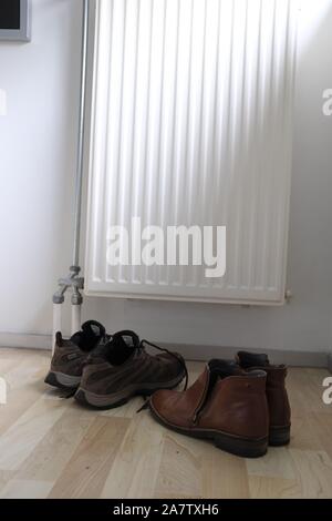 Shoes next to a radiator Stock Photo - Alamy