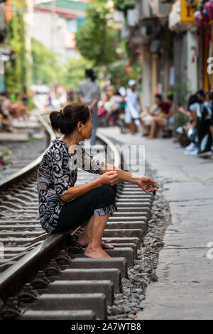 Happy Asian woman sits on outdoor balcony net hammock, enjoying green ...