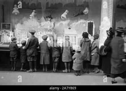 Children looking into store window along a New York City street with ...