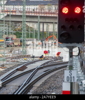 Ulm, Germany. 05th Nov, 2019. A train passes track workers at the main ...