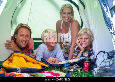 happy family with children camping in the forest. relaxing in tent ...