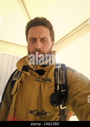 On guard. Firefighter with uniform taking selfie. Masculinity and male ...