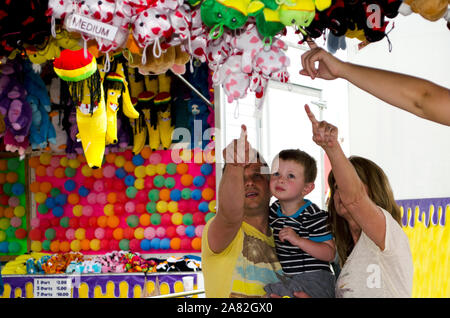 Woman choosing prize at a carnival game Stock Photo - Alamy