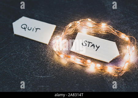 changing job conceptual still-life, stay vs quit text on signs pointing ...
