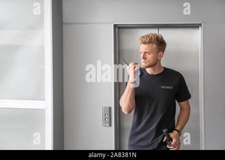 Male security guard near elevator Stock Photo - Alamy