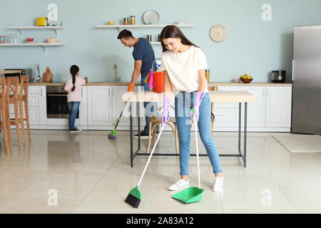 Happy family cleaning kitchen together Stock Photo - Alamy