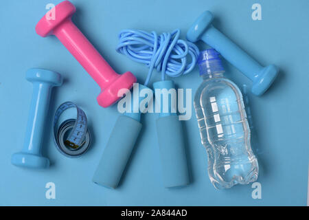 Dumbbells, skipping rope in cyan color near water bottle Stock Photo ...