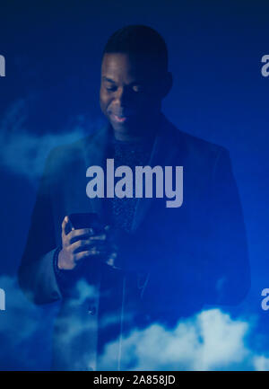young businessman smiling while using his phone Stock Photo - Alamy