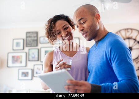 Happy couple using digital tablet in bedroom Stock Photo - Alamy