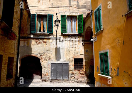 Pastel coloured stone buildings with green wooden shutters in the ...
