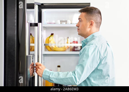 man looking in fridge Stock Photo - Alamy