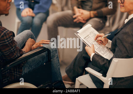 Senior woman sitting and filling up documents at kitchen table Stock ...
