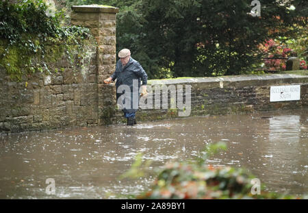 A man walks through a flooded area after a week of torrential rains in ...
