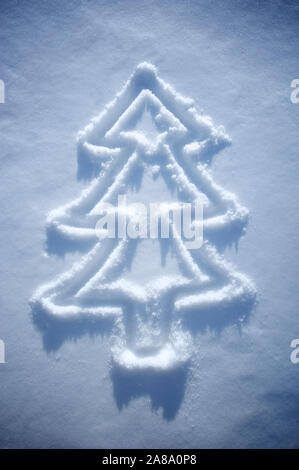 Simple textured Christmas tree drawn in fresh powder snow in bright ...