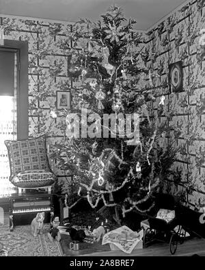 Christmas tree with presents in early 1900s home Stock Photo - Alamy