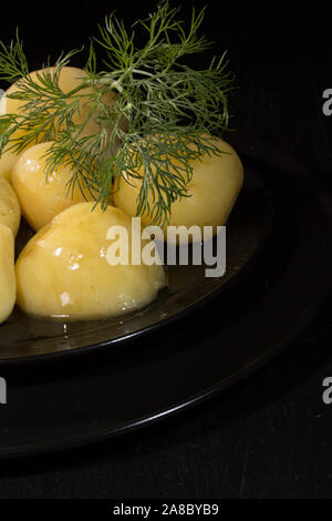 Welded potatoes on a black plate on a dark background Stock Photo - Alamy
