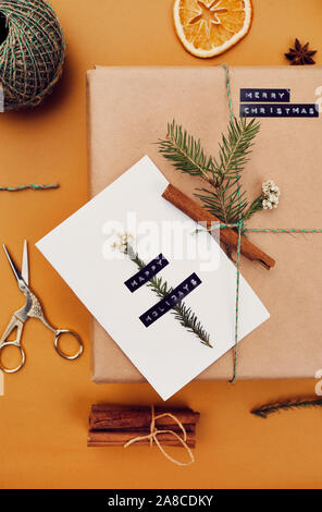 Christmas greeting card with gift box and fir tree branch over wooden ...