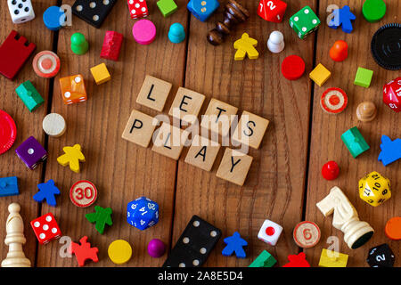 "Lets Game" spelled out in wooden letter tiles. Surrounded by dice ...