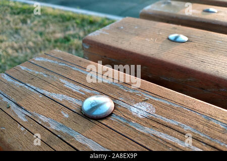 Close-up of wooden boards fastened with metal nails on a bench outdoors ...