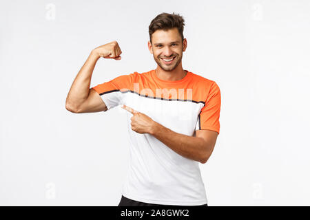 Cheerful young pointing at his arm muscles while recoding video Stock ...
