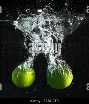 fresh lime falling in water Stock Photo - Alamy