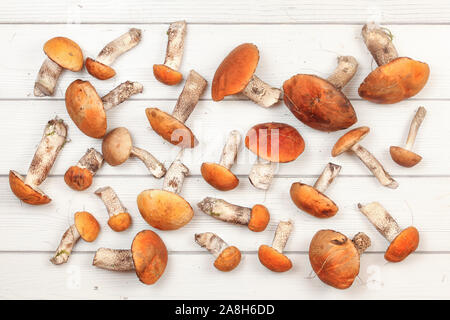 Overhead view of harvested mushrooms in containers on wooden table ...