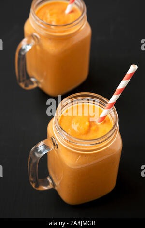 Homemade pumpkin smoothie in a glass jar mug, side view. Copy space ...