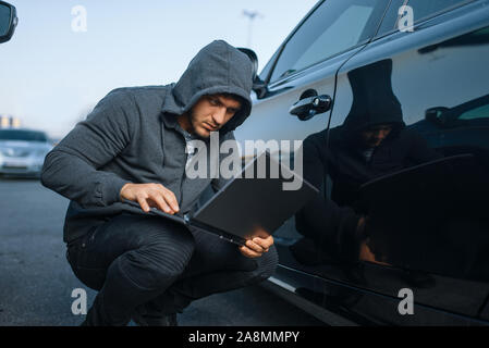 Thief hacking car system with laptop inside vehicle, closeup Stock ...
