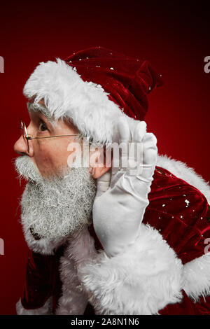 Portrait of Santa Claus trying to hear something on white background ...