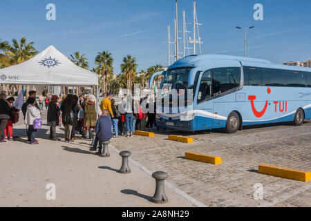 Vacationers lining up at a tour bus of TUI, shuttle bus bringing them ...