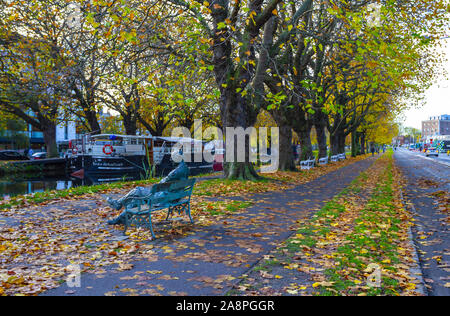 Bronze sculpture of poet Patrick Kavanagh at Grand Canal. People enjoy ...