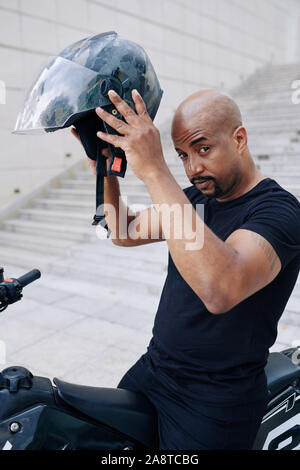 Handsome mixed-race man sitting on ground and calling mechanic as his ...
