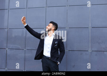 Handsome arabic man takes selfie smart phone in business center Stock ...