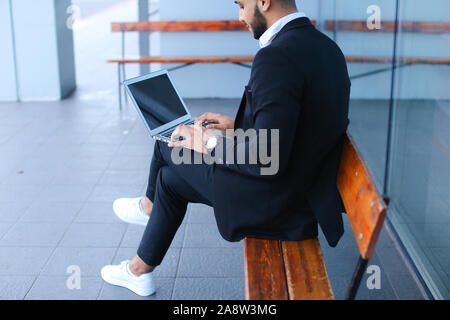 Cool guy arabic man uses laptop business center Stock Photo - Alamy