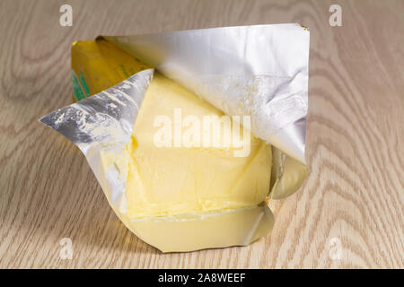 Open pack of butter on wooden chopping board Stock Photo - Alamy