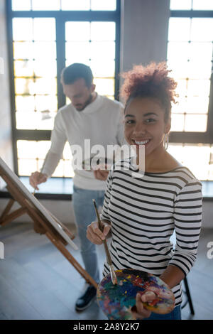 Young african american artist man sitting on wheelchair at art studio ...